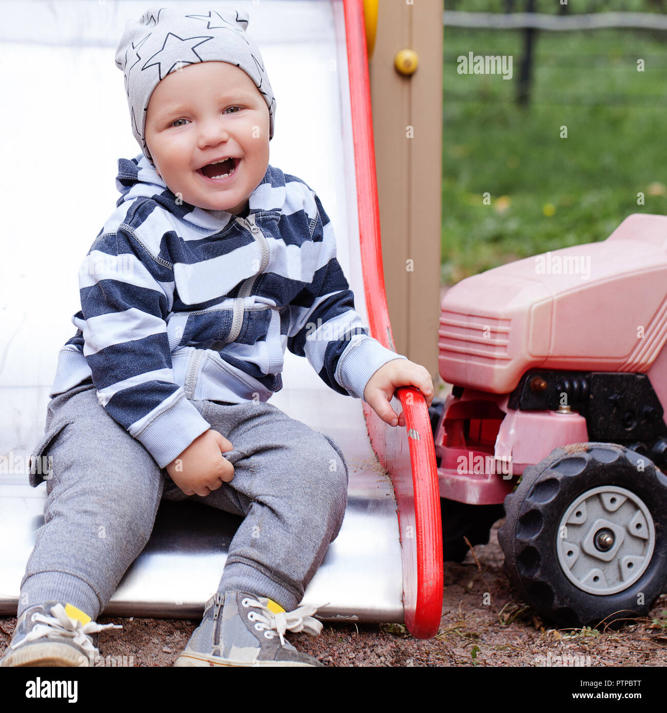 Happy child playing outdoors in playground, portrait Stock Photo - Alamy