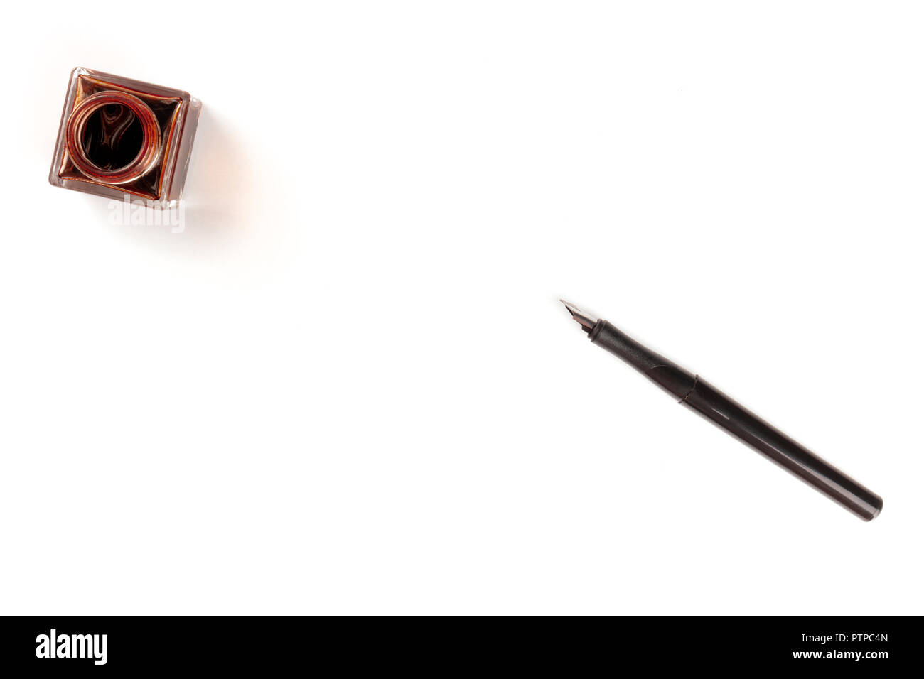 An overhead photo of an ink well and an ink pen, shot from above on a ...
