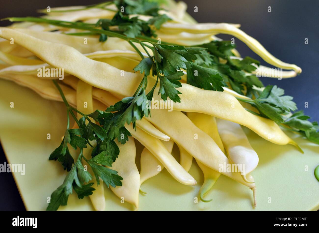 Close up of string green fresh beans seasoned with parsley on white ...