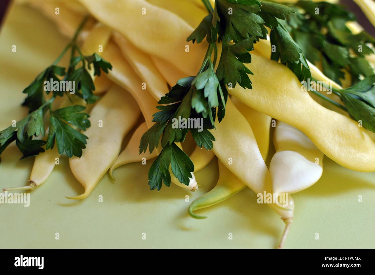 Close up of string green fresh beans seasoned with parsley on white ...