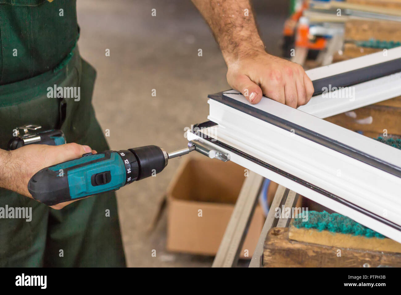 Production of pvc windows, a man screws a screwdriver into a pvc window ...
