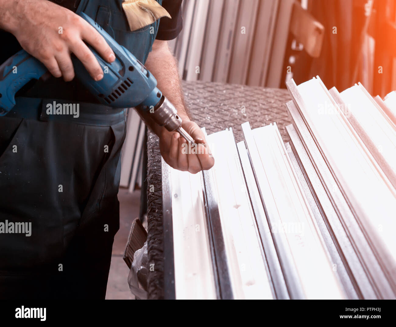 Production of pvc windows, the worker is screwed with a screwdriver ...