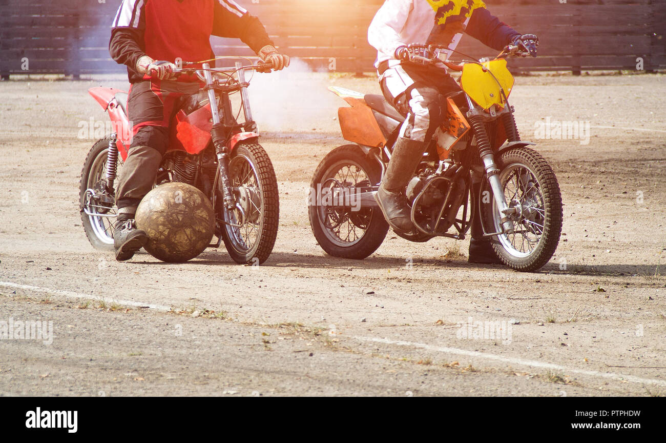 Motoball, teens play motoball on motorcycles with a ball, two players ...
