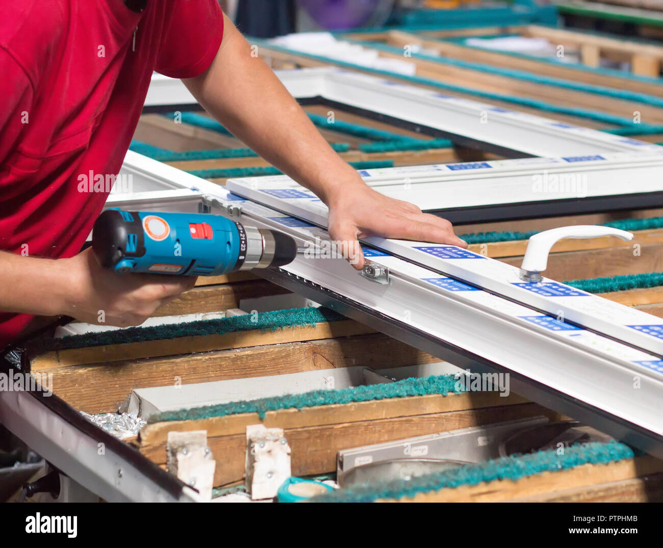 Production of pvc windows, the worker is screwed with a screwdriver ...
