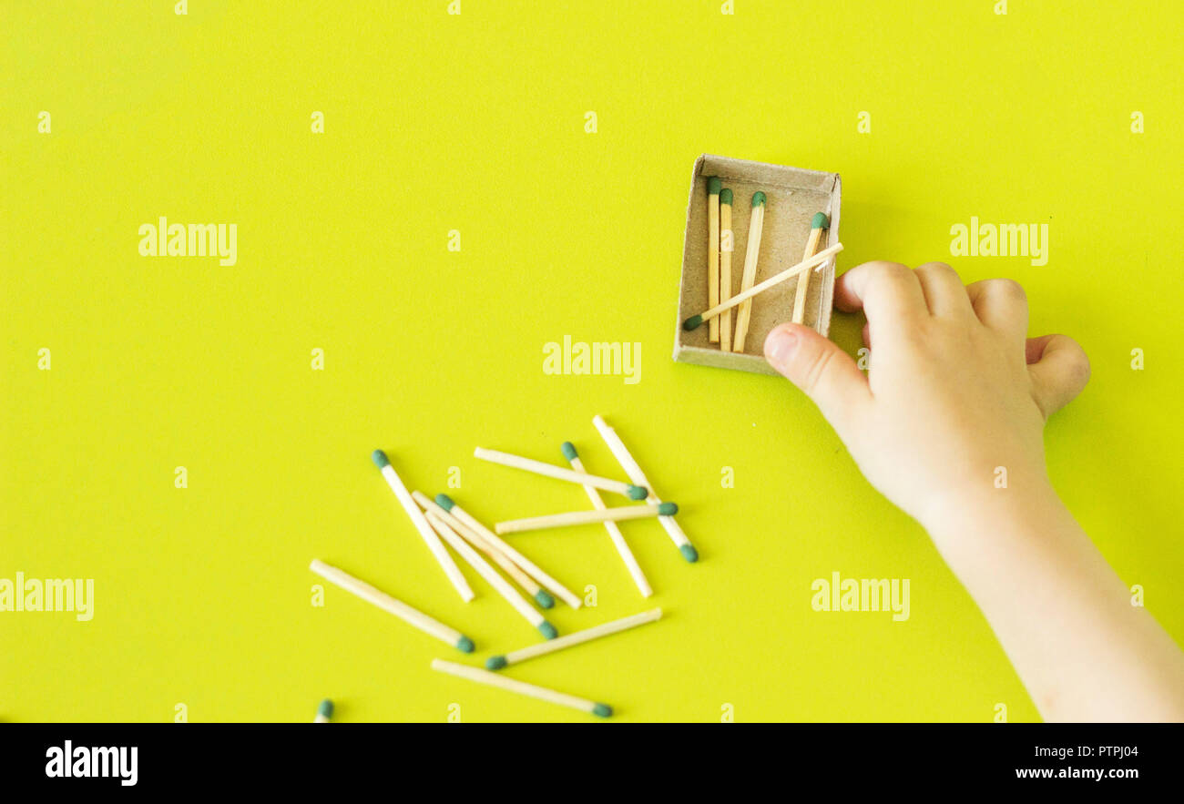 A small child plays with matches, matches matches into boxes, close-ups ...