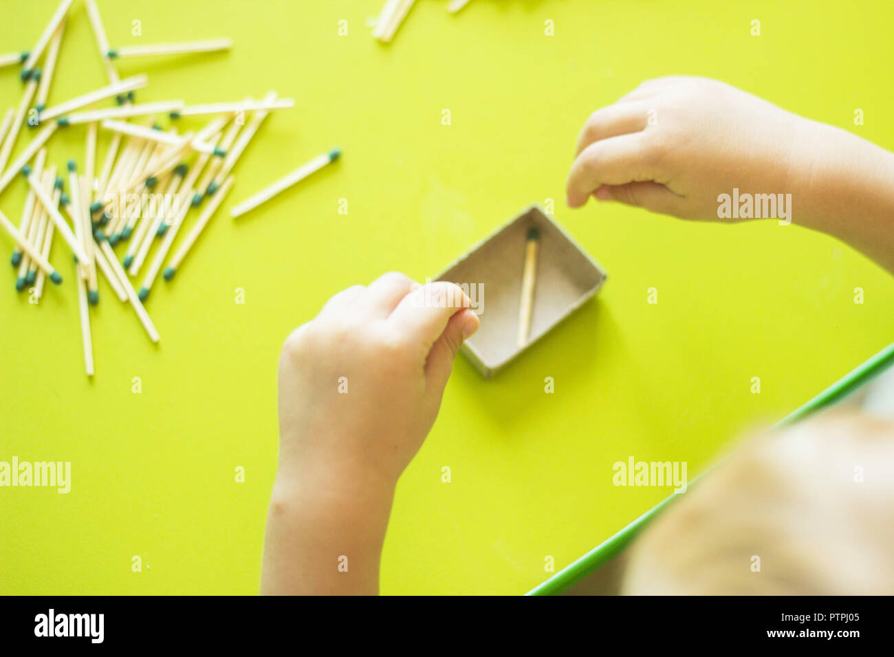 A small child plays with matches, matches matches into boxes, close-ups ...