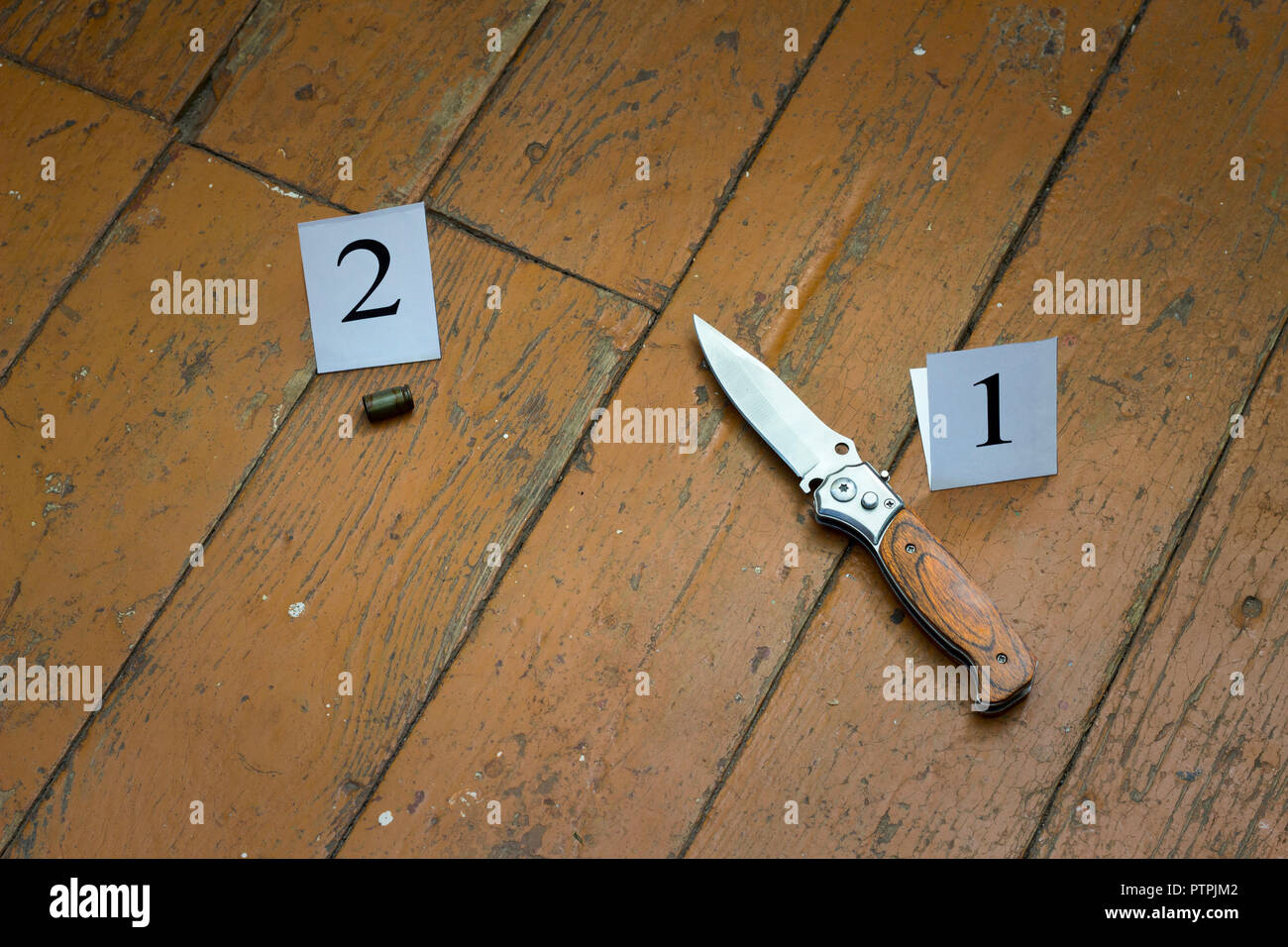 Knife and cartridge case on a brown wooden background, murder, robbery ...