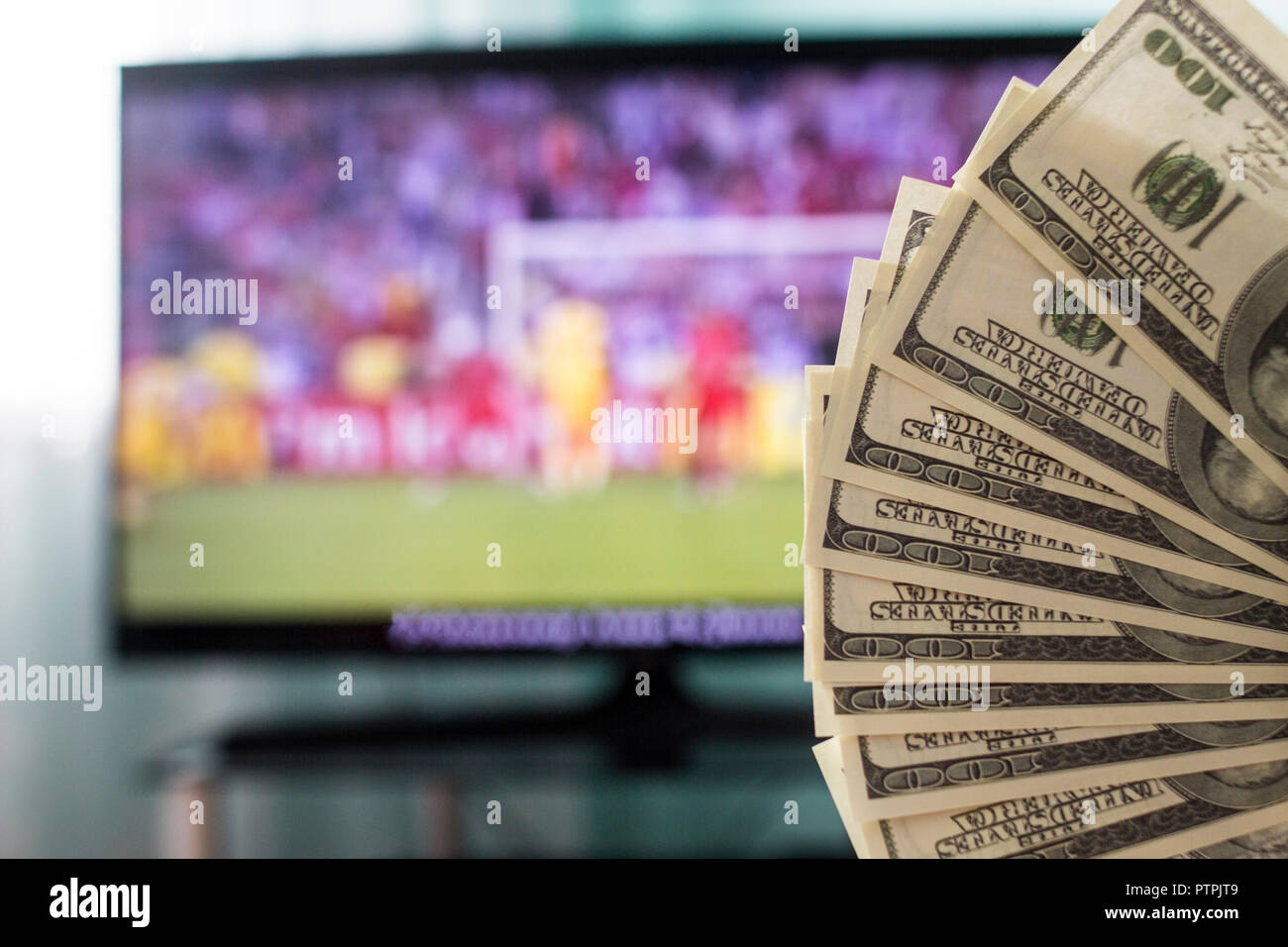 Dollars against the backdrop of a TV set for football, football and ...