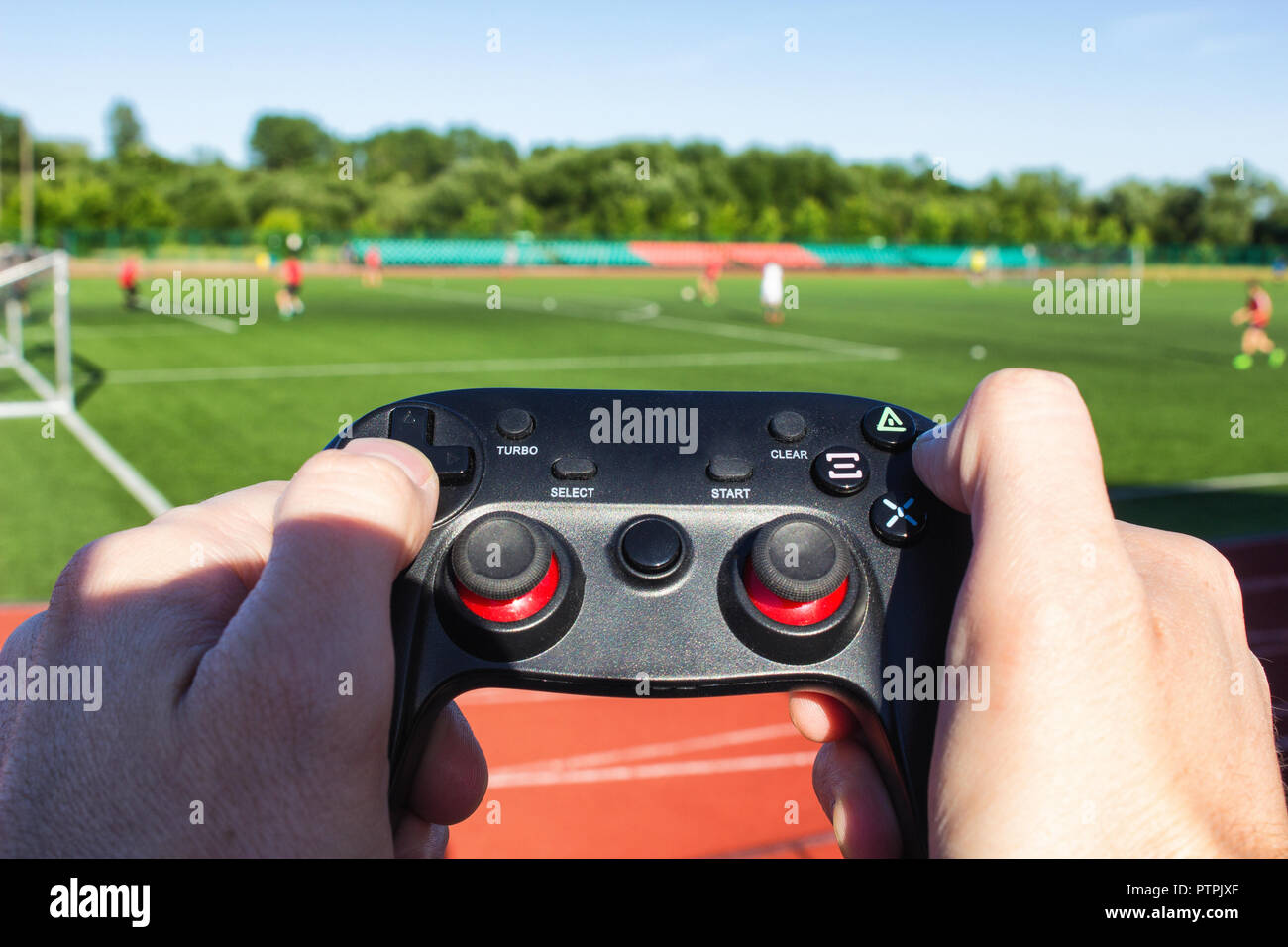 Men's hands hold a game joystick and press buttons on the background of ...