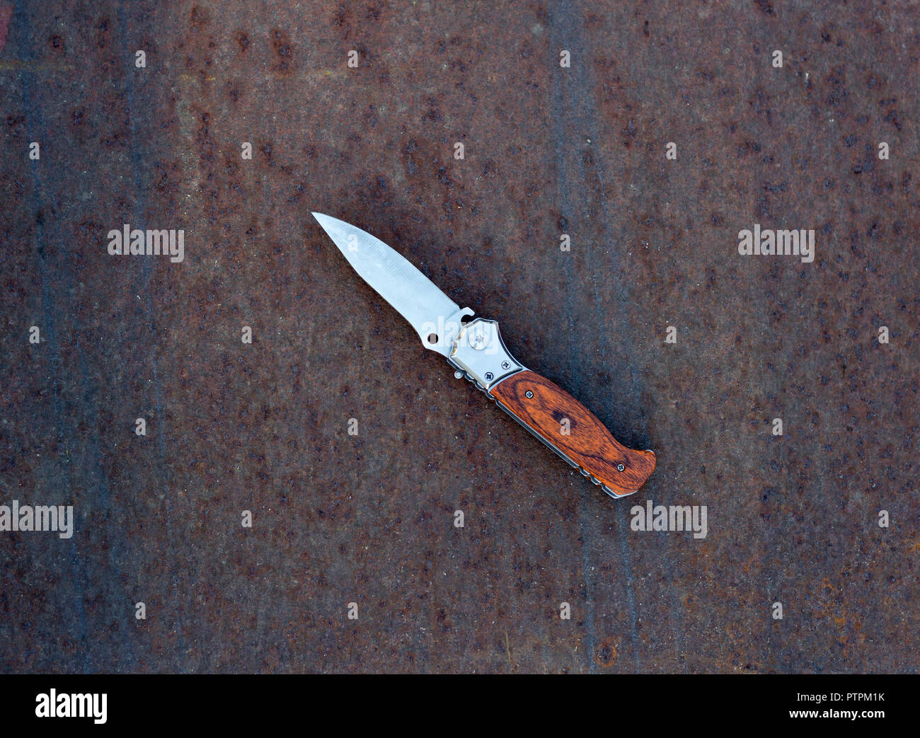 Folding knife on rusty metal background, close up Stock Photo - Alamy