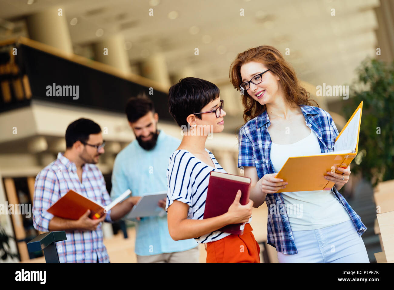 Group of college students studying at library Stock Photo - Alamy