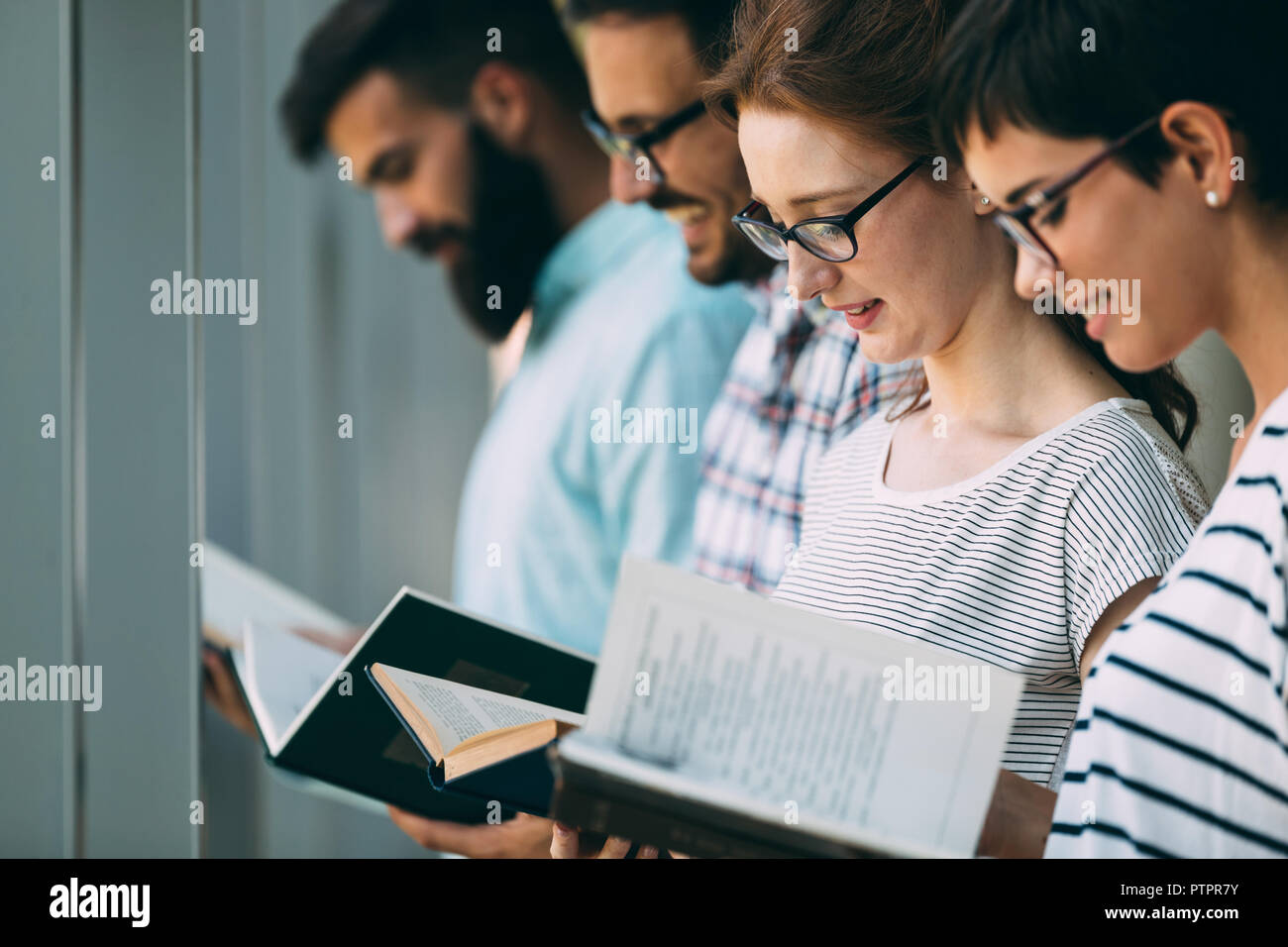 Group of college students studying at library Stock Photo - Alamy