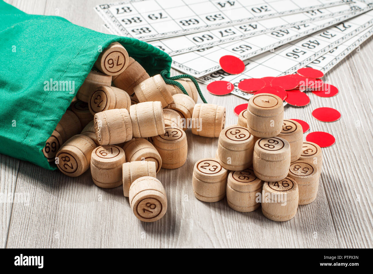 Board game lotto. Stacked wooden lotto barrels with bag, game cards and ...