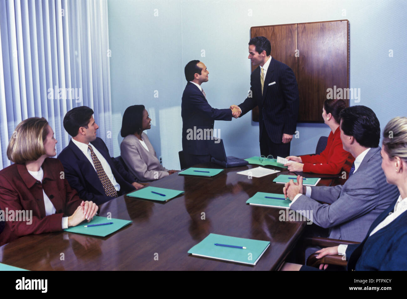 1995 HISTORICAL MULTI ETHNIC OFFICE WORKERS IN LARGE GROUP BOARDROOM ...