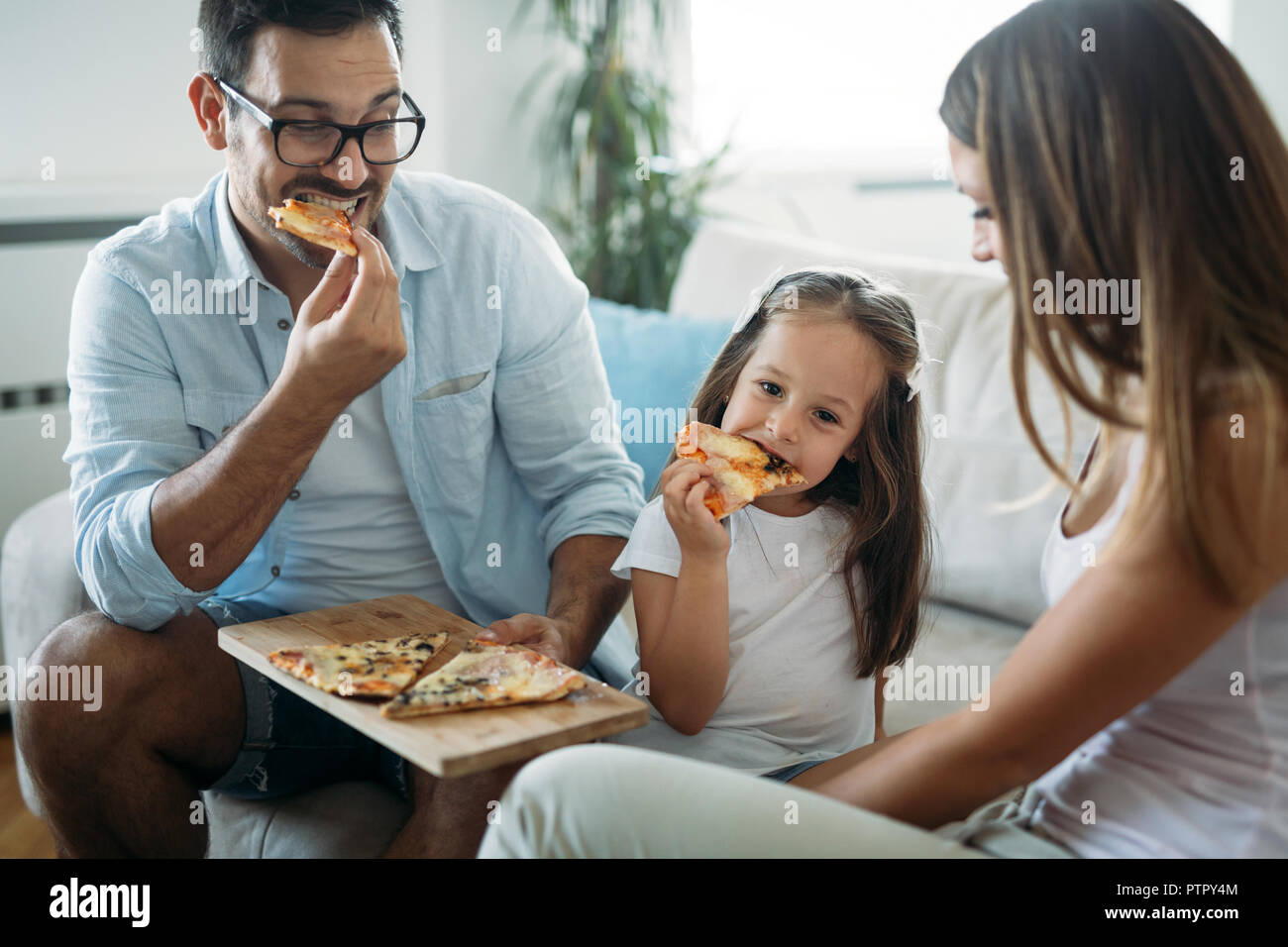Portrait of happy family sharing pizza at home Stock Photo - Alamy