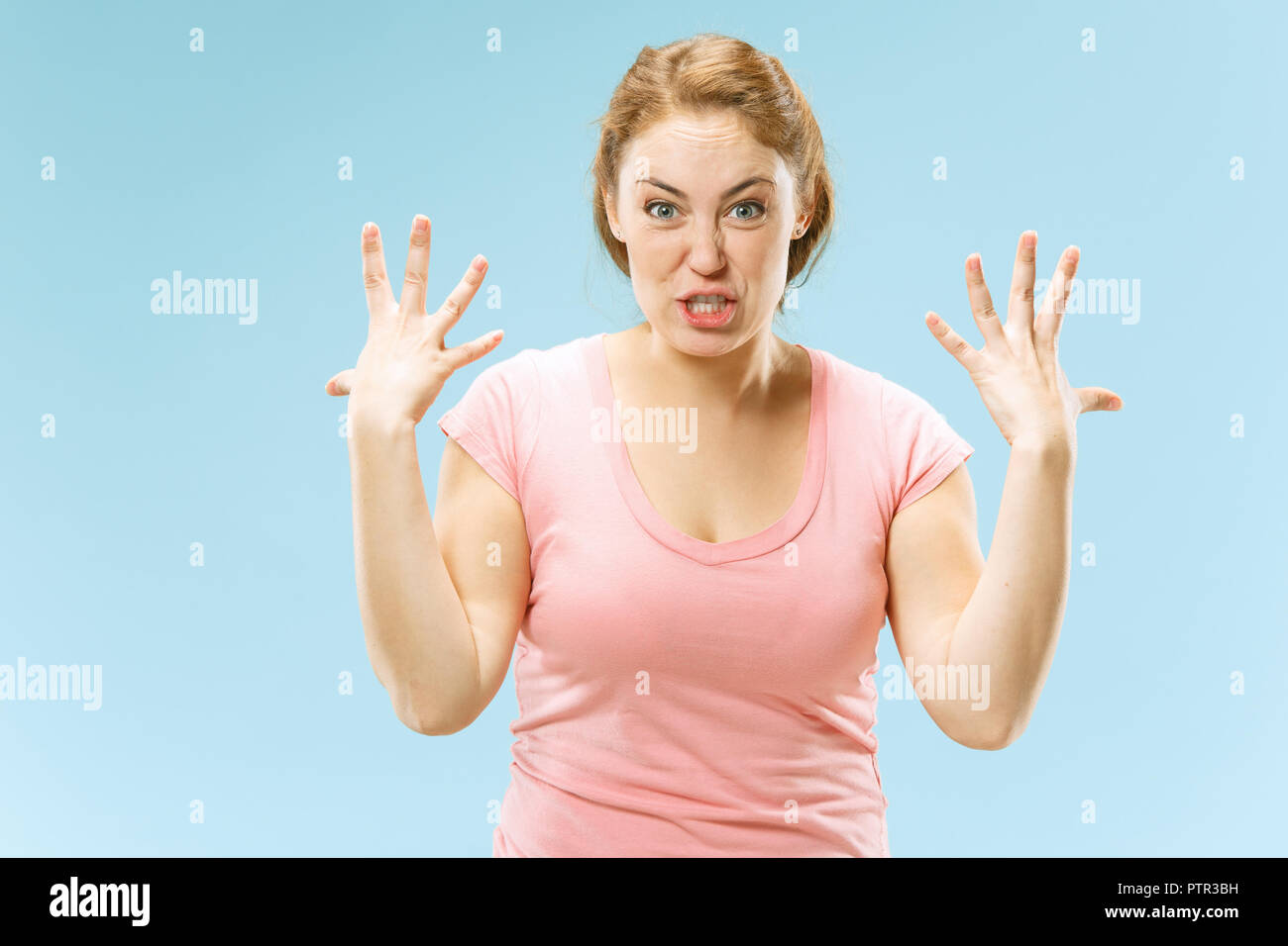 Argue, arguing concept. Beautiful female half-length portrait isolated on blue studio backgroud ...