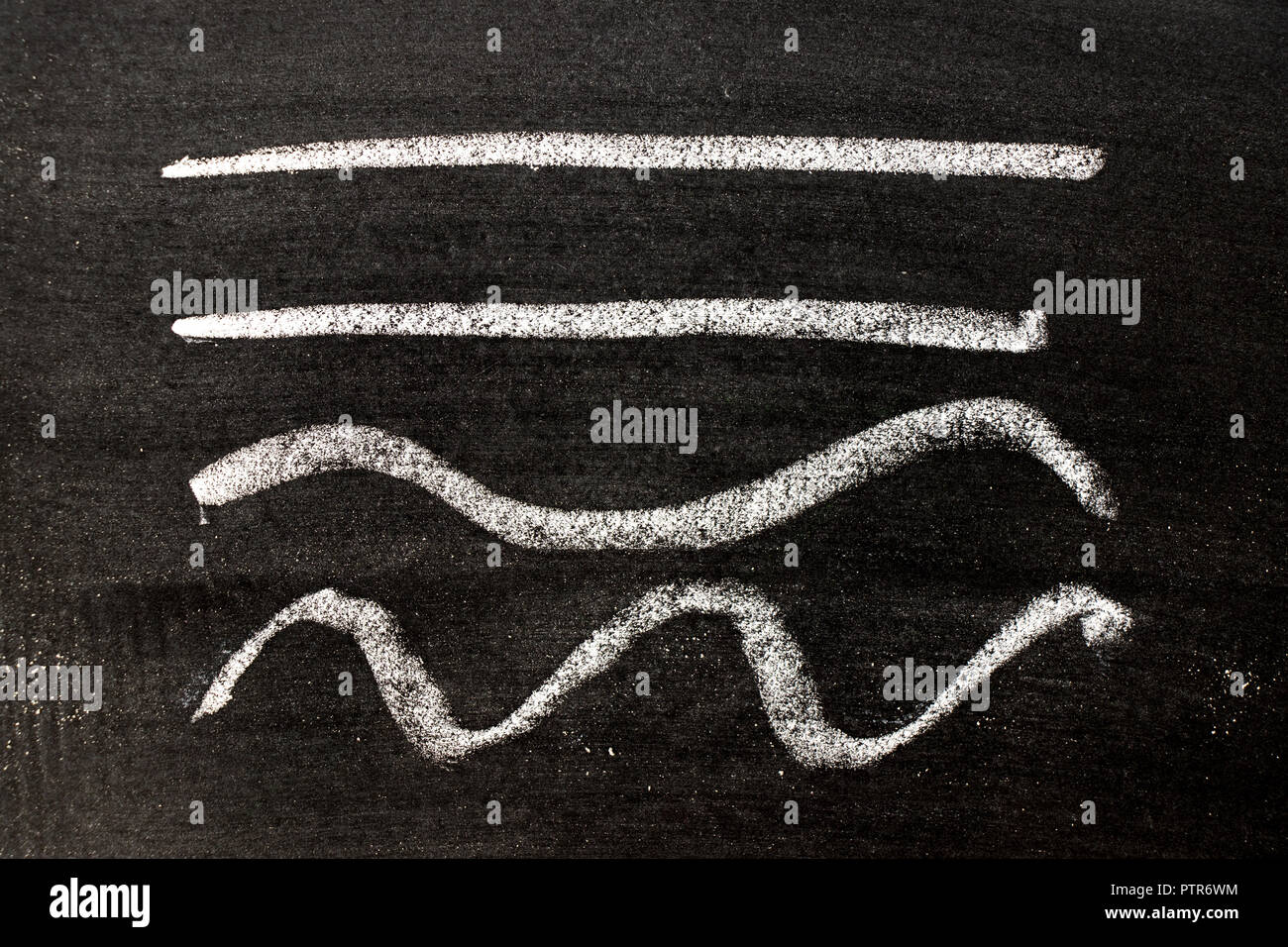 White color chalk hand drawing as line shape on black board background ...