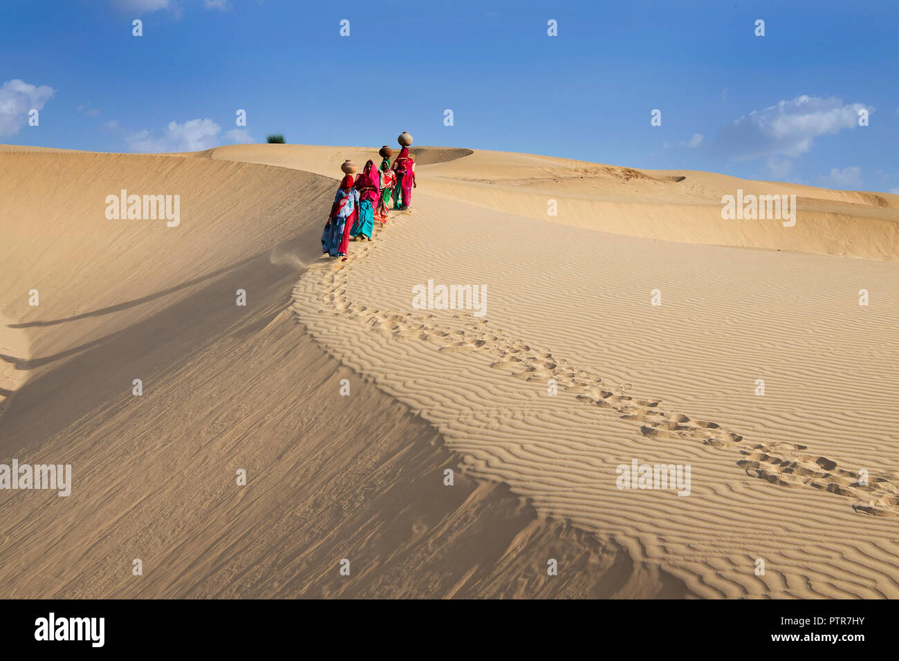 The image of Rajasthani traditional ladies with pots in sand dunes of ...