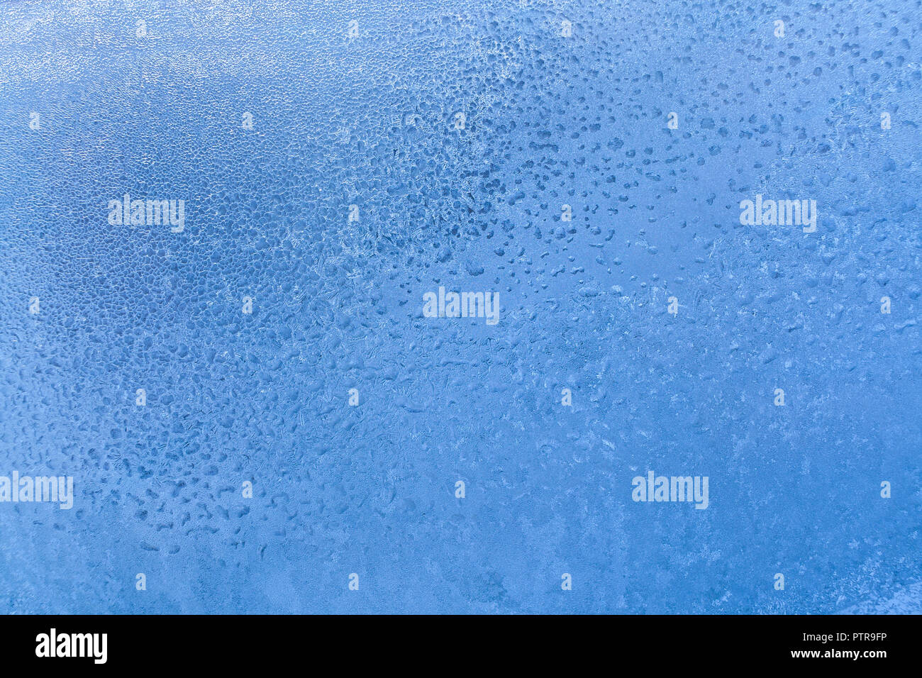 Blue frozen window glass with icy drawing with fine structure as ...