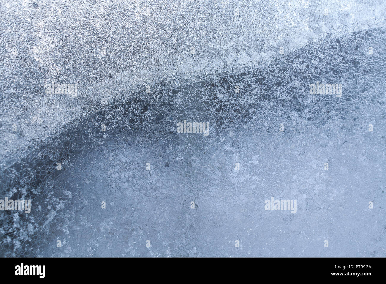 Openwork icy drawing on frozen window glass as background or wallpaper ...