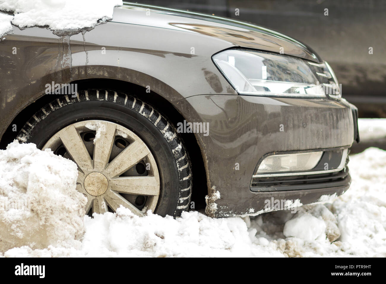 Close-up detail front part of car, wheel, bumper and hood in deep snow ...