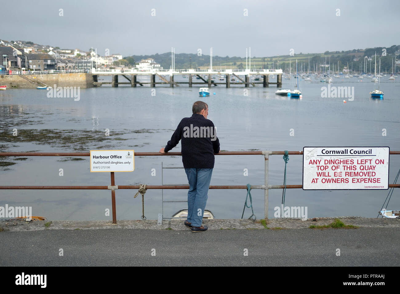 A man standing alone on a quay in Falmouth, Cornwall Stock Photo - Alamy