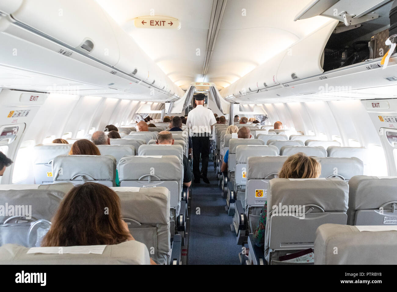 Interior of commercial airplane with unrecognizable passengers on their ...