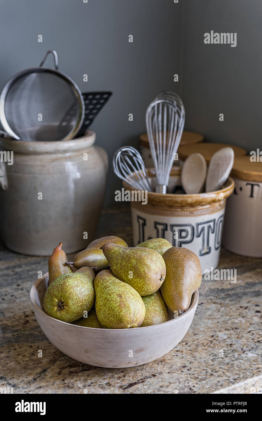 Bowl of pears with utensils in ceramic pots in 16th century farmhouse ...