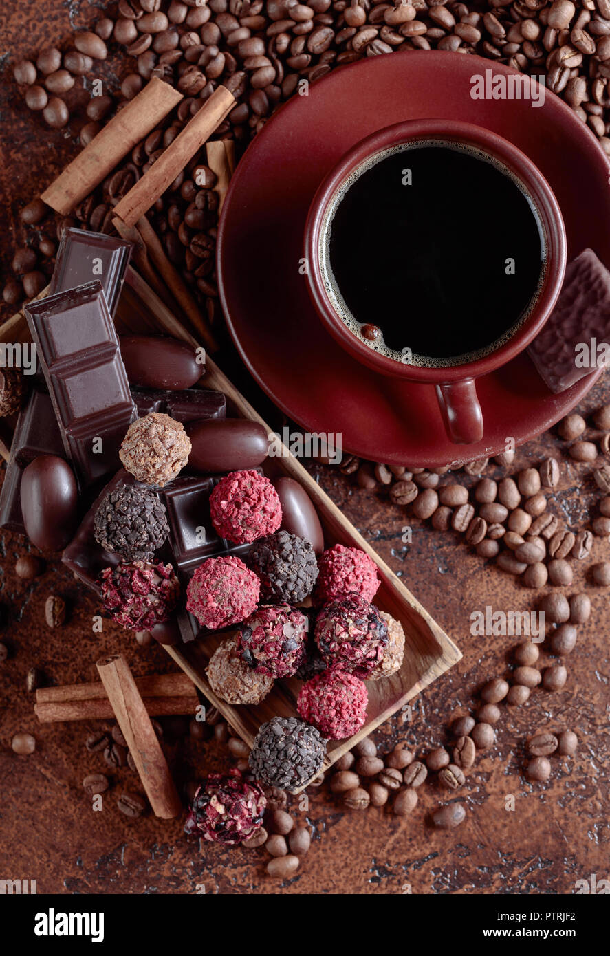 Various chocolates and cup of black coffee. Sweets with cinnamon sticks ...