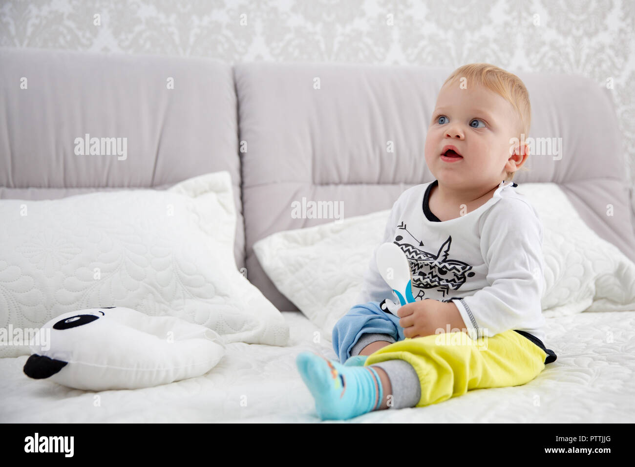 Playful little boy wearing blue pyjamas in bedof parents Stock Photo ...