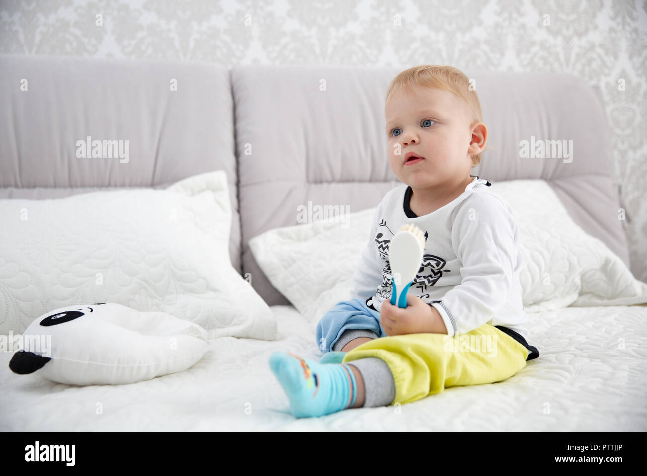 Playful little boy wearing blue pyjamas in bedof parents Stock Photo ...
