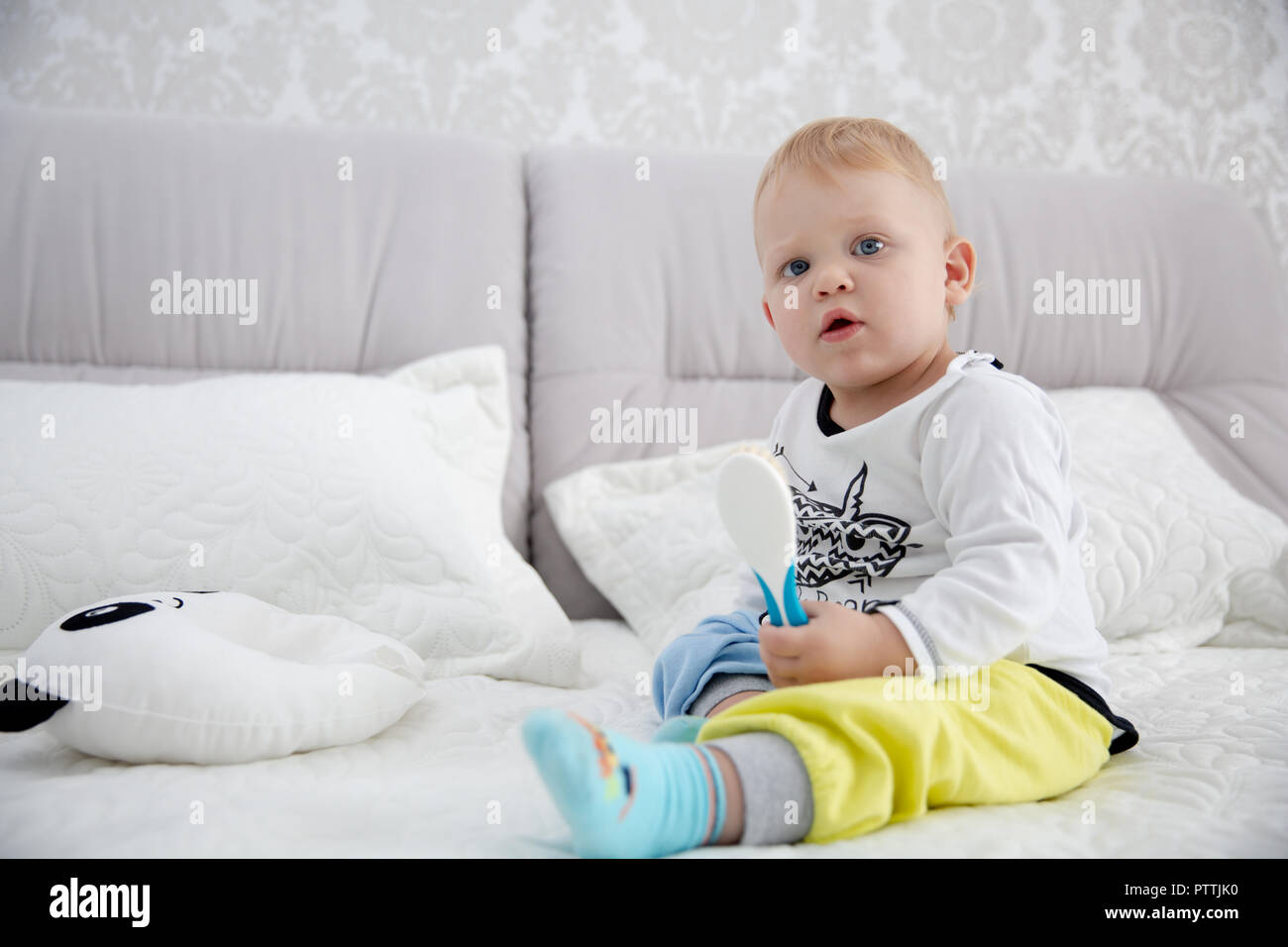 Playful little boy wearing blue pyjamas in bedof parents Stock Photo ...