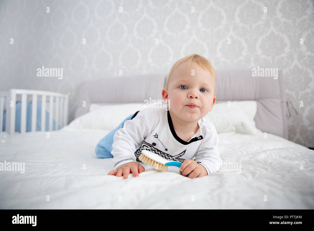 Playful little boy wearing blue pyjamas in bedof parents Stock Photo ...