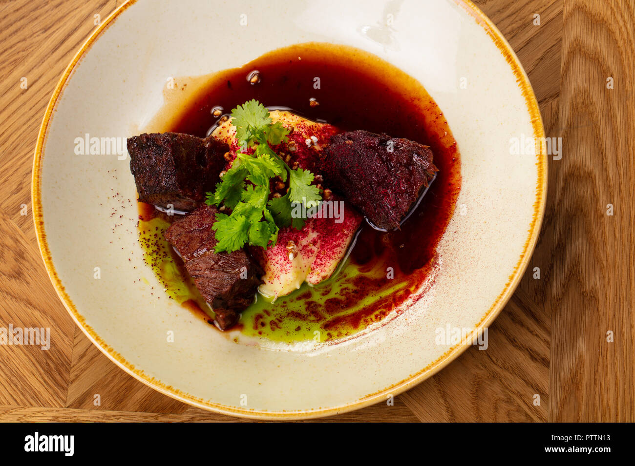 Fried beef cheeks with sauce Stock Photo - Alamy