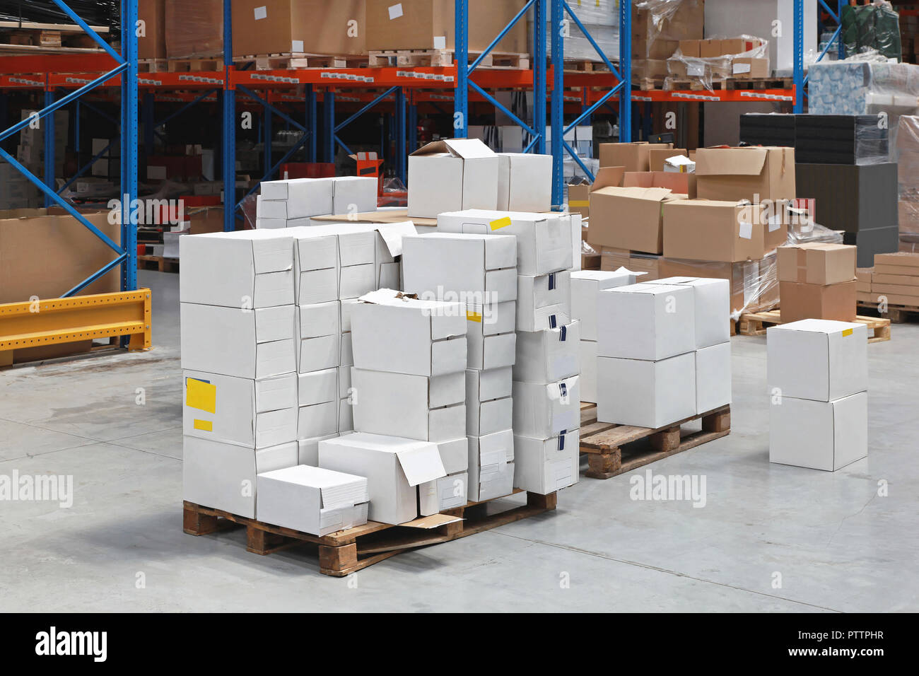 Pile of boxes at pallets in distribution warehouse Stock Photo - Alamy