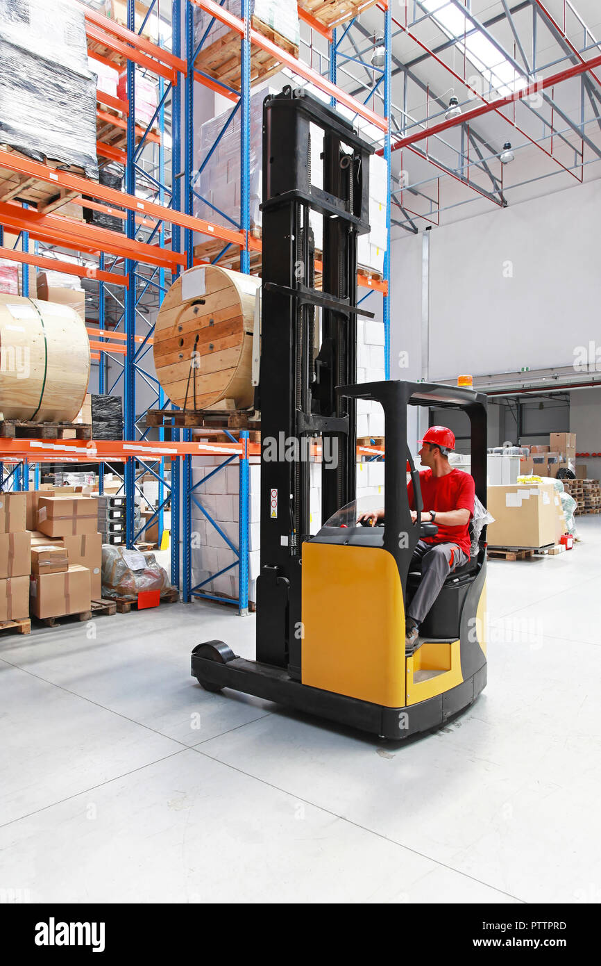 Forklift loading pallet with roll in distribution warehouse Stock Photo ...
