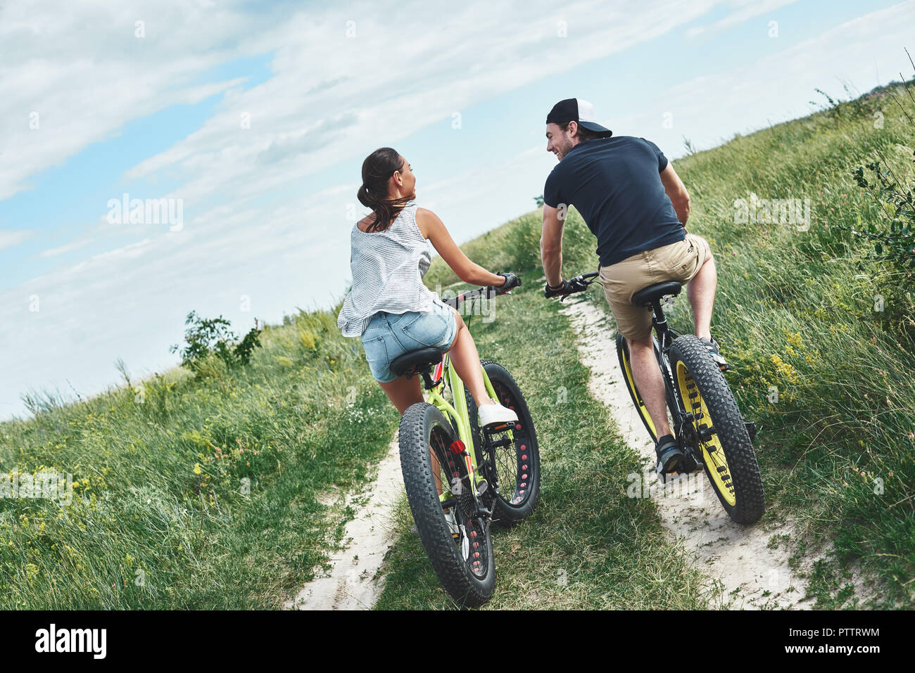 Back view of woman riding bicycle hi-res stock photography and images ...