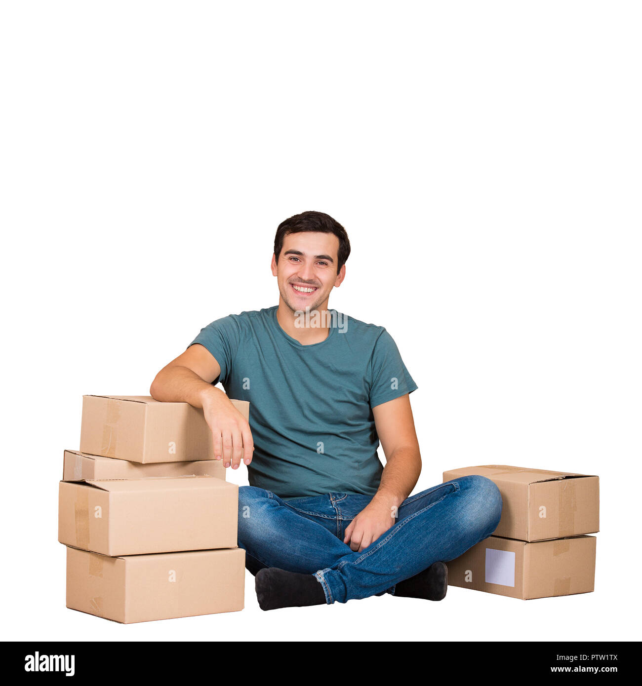 Young excited man sitting on the floor lean on cardboard boxes ready ...