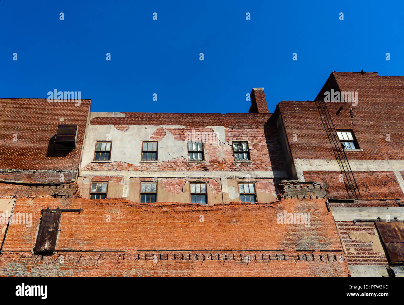 Old grungy brick building that has been partially torn down and is ...