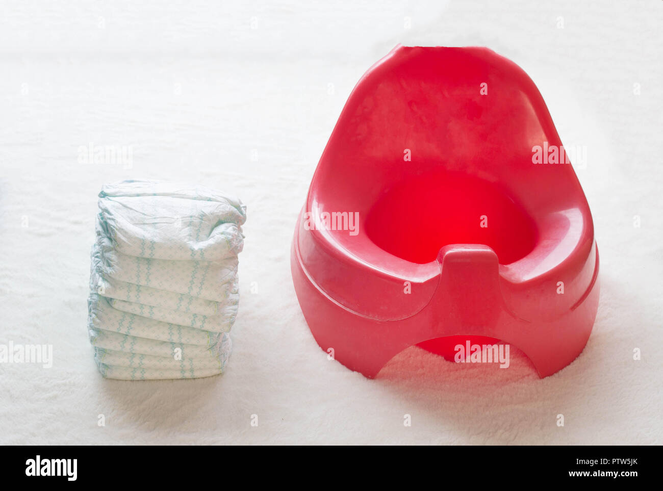 Children's red pot and a stack of diapers, hygiene Stock Photo - Alamy