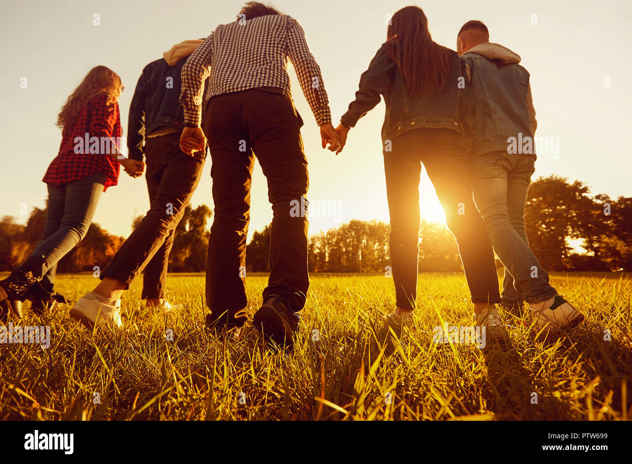 Group Holding Hands Sunset