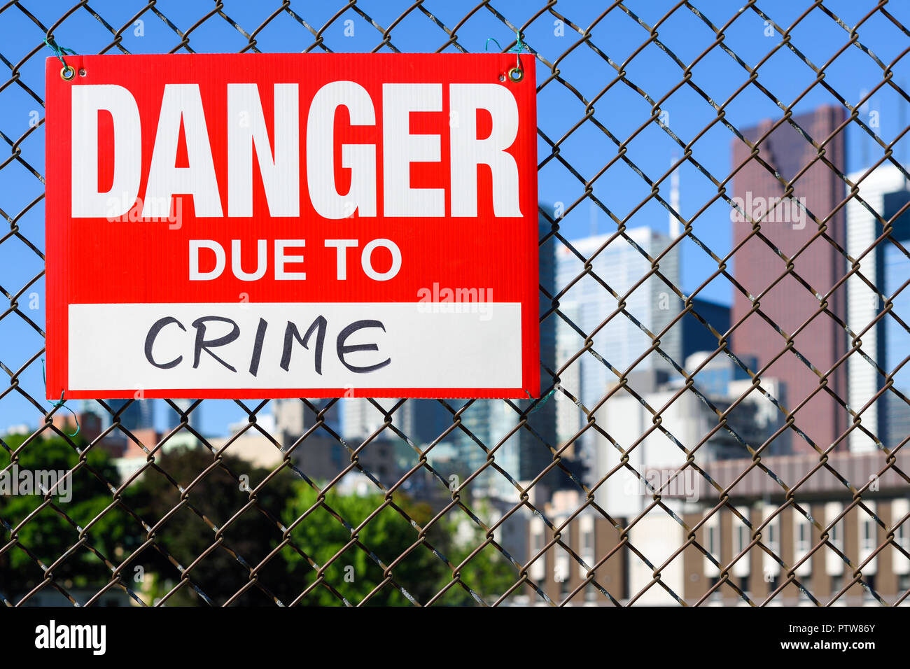Sign danger due to crime attached on the fence in the front of the town ...