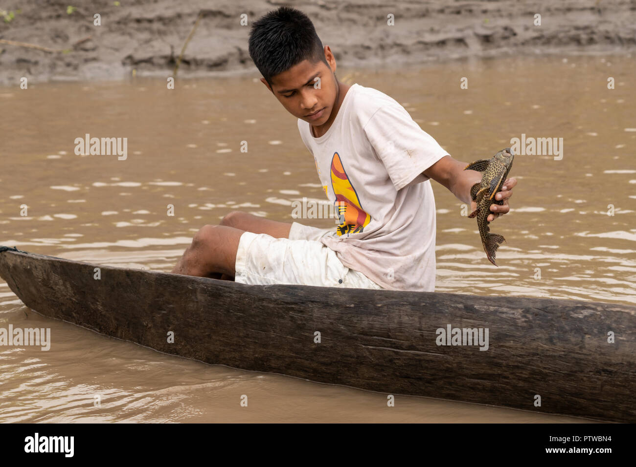 Pacaya Samiria Reserve, Peru, South America. Boy in a dugout canoe ...
