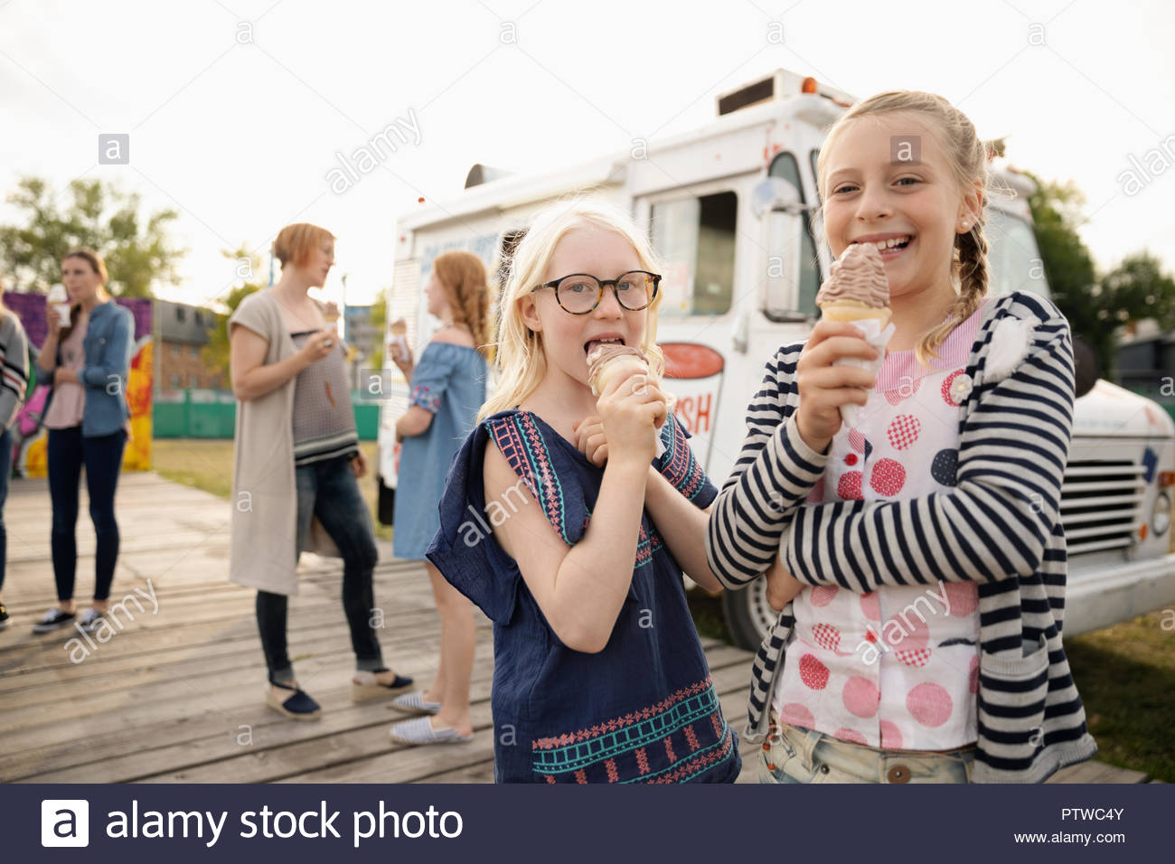 Portrait smiling, cute girls eating ice cream Stock Photo - Alamy