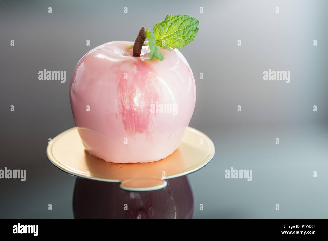 Trendy pink mirror glazed mousse cake in shape of apple Stock Photo - Alamy