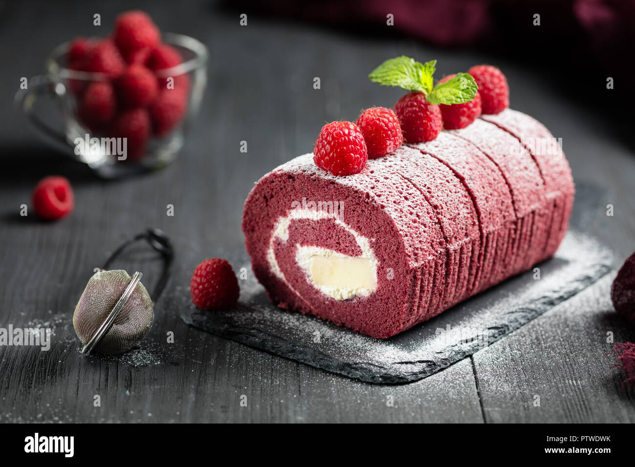 Sponge Swiss roll with fresh raspberry and sugar icing on dark ...