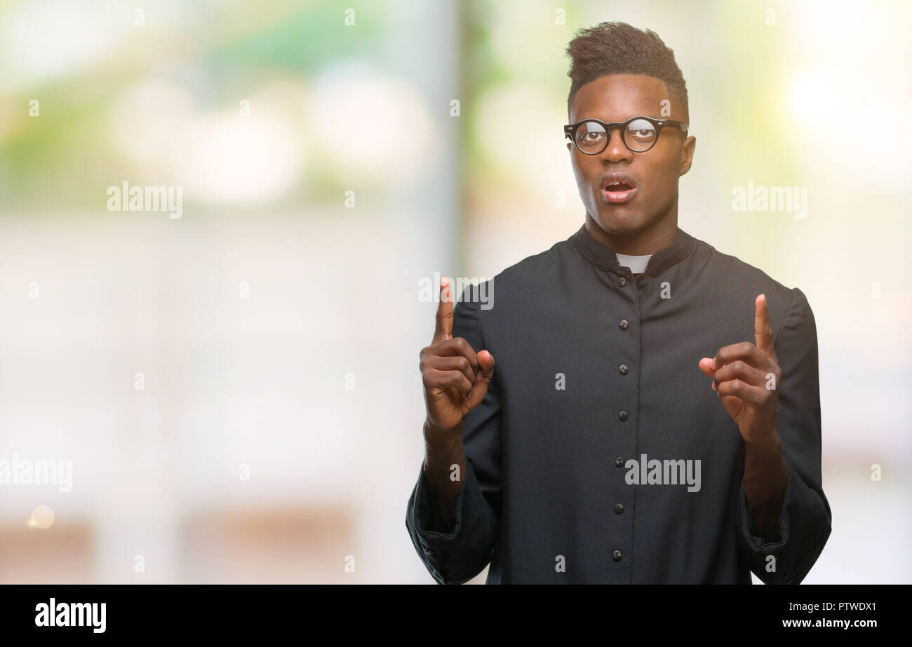 Young african american priest man over isolated background amazed and ...