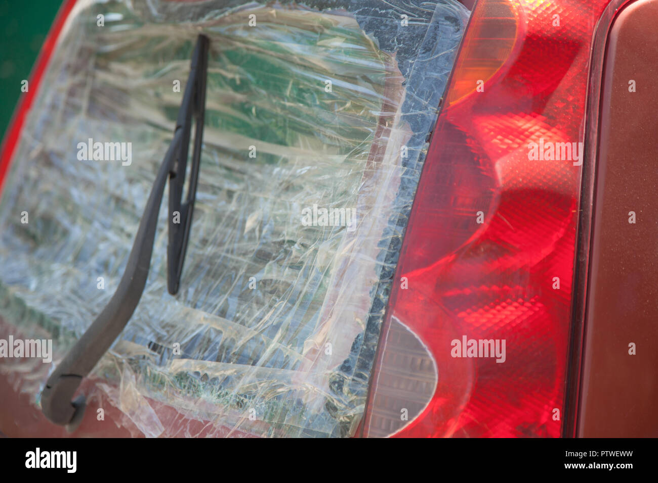 broken car rear window sealed with scotch tape Stock Photo - Alamy