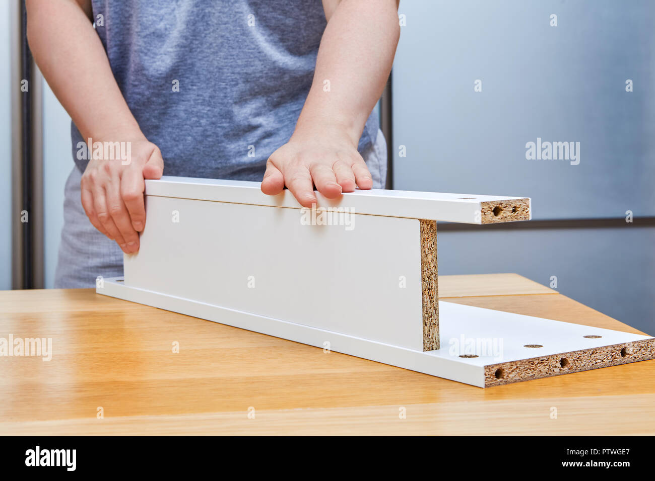 Self-assembly of furniture at home, women's hands join together parts ...