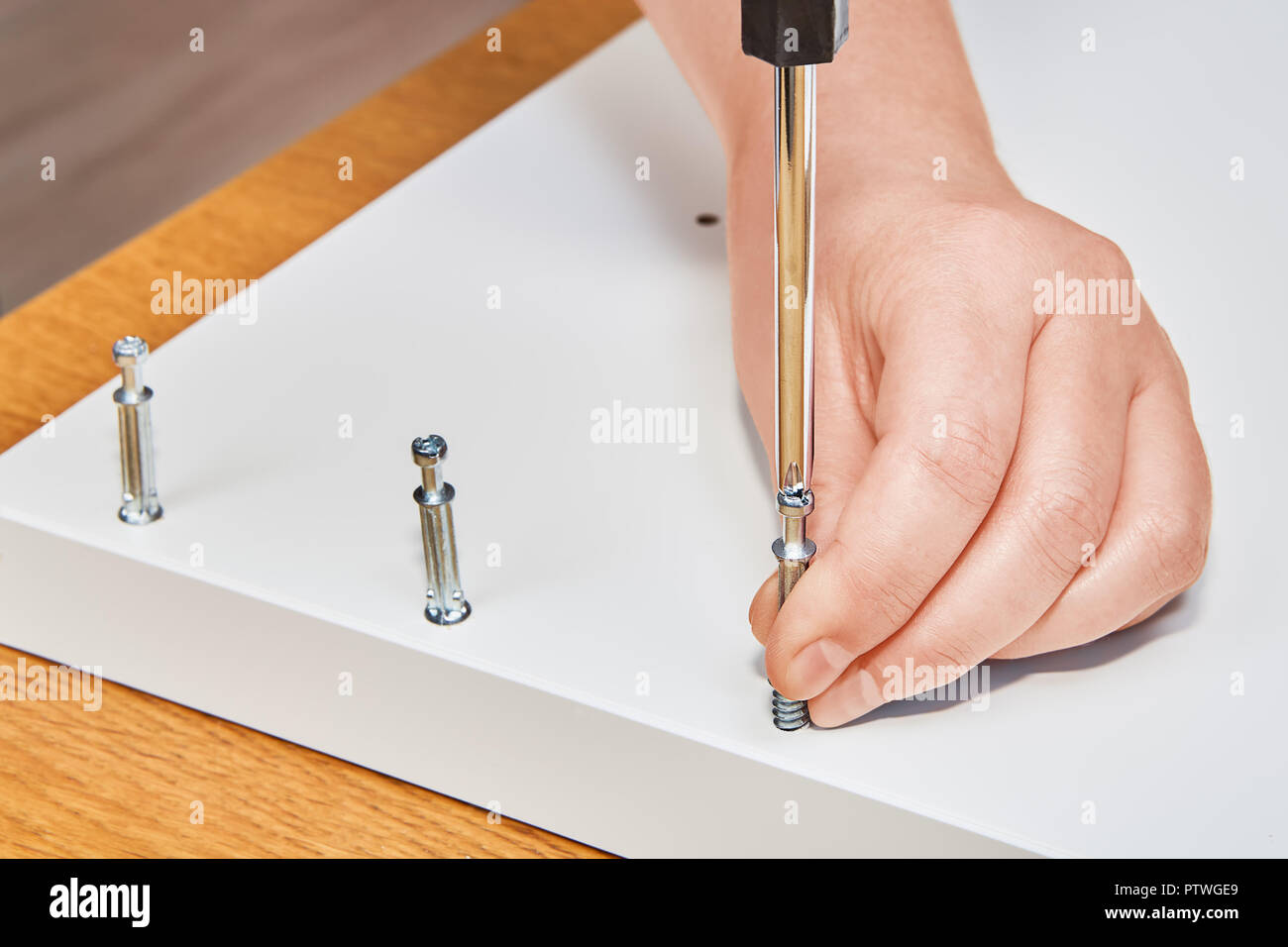Hands Of Furniture Assembler Is Screwing Furniture Joint Connector